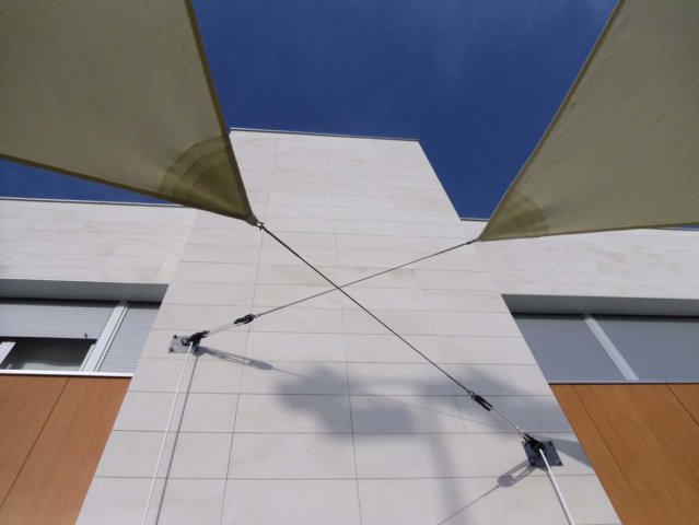 Installation of sail awnings. Sail tensioning by means of nautical pulleys.